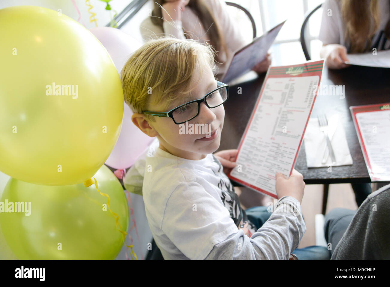 A child orders from a cafe menu at a birthday party Stock Photo - Alamy