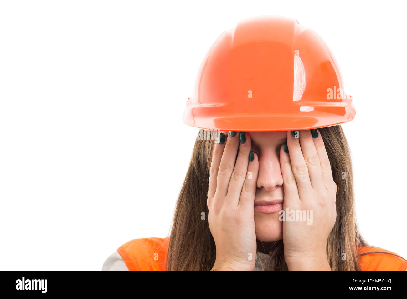 Portrait of scared woman engineer covering eyes with hands on white ...