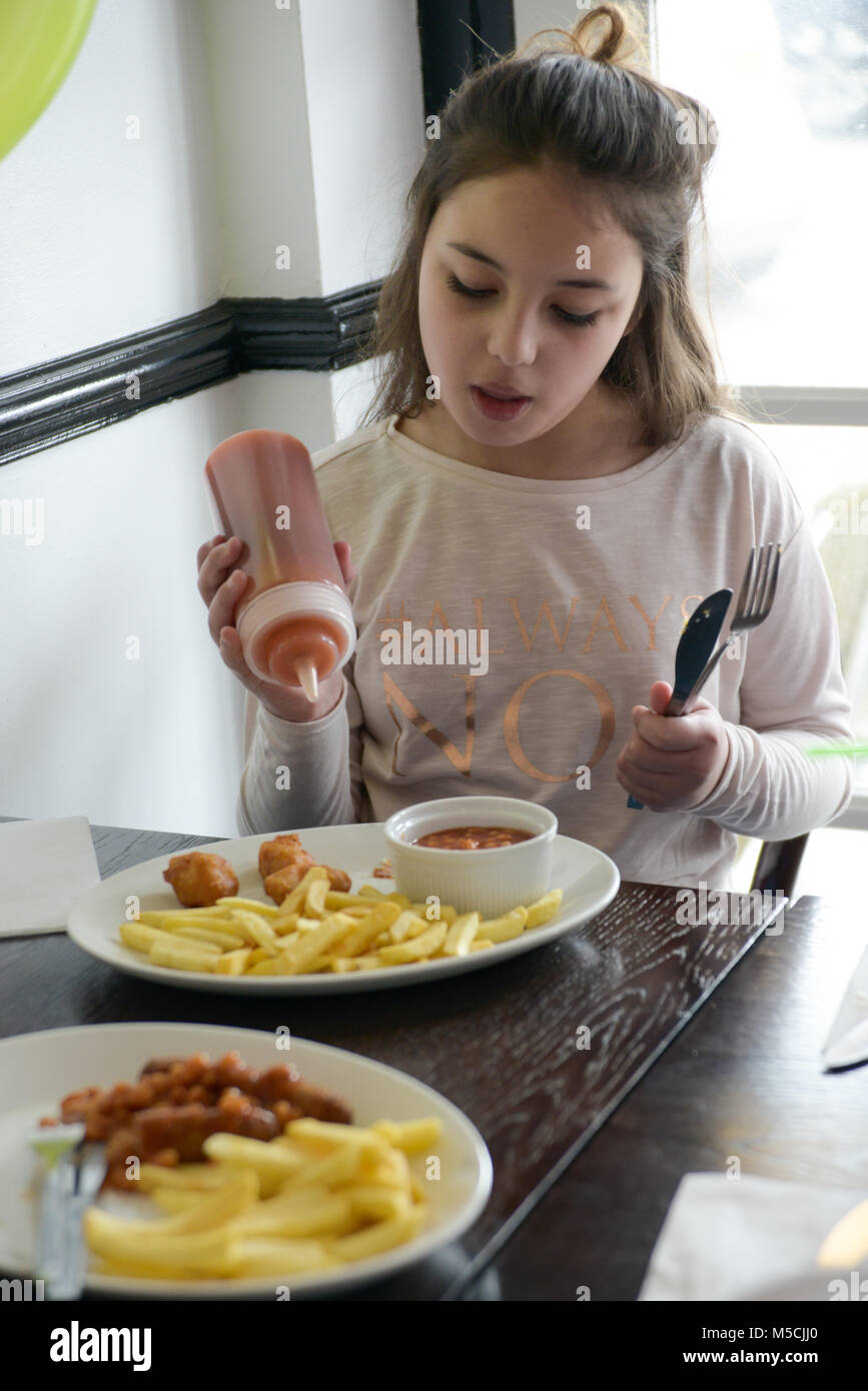 Portrait of a child eating fried food at a party table Stock Photo - Alamy