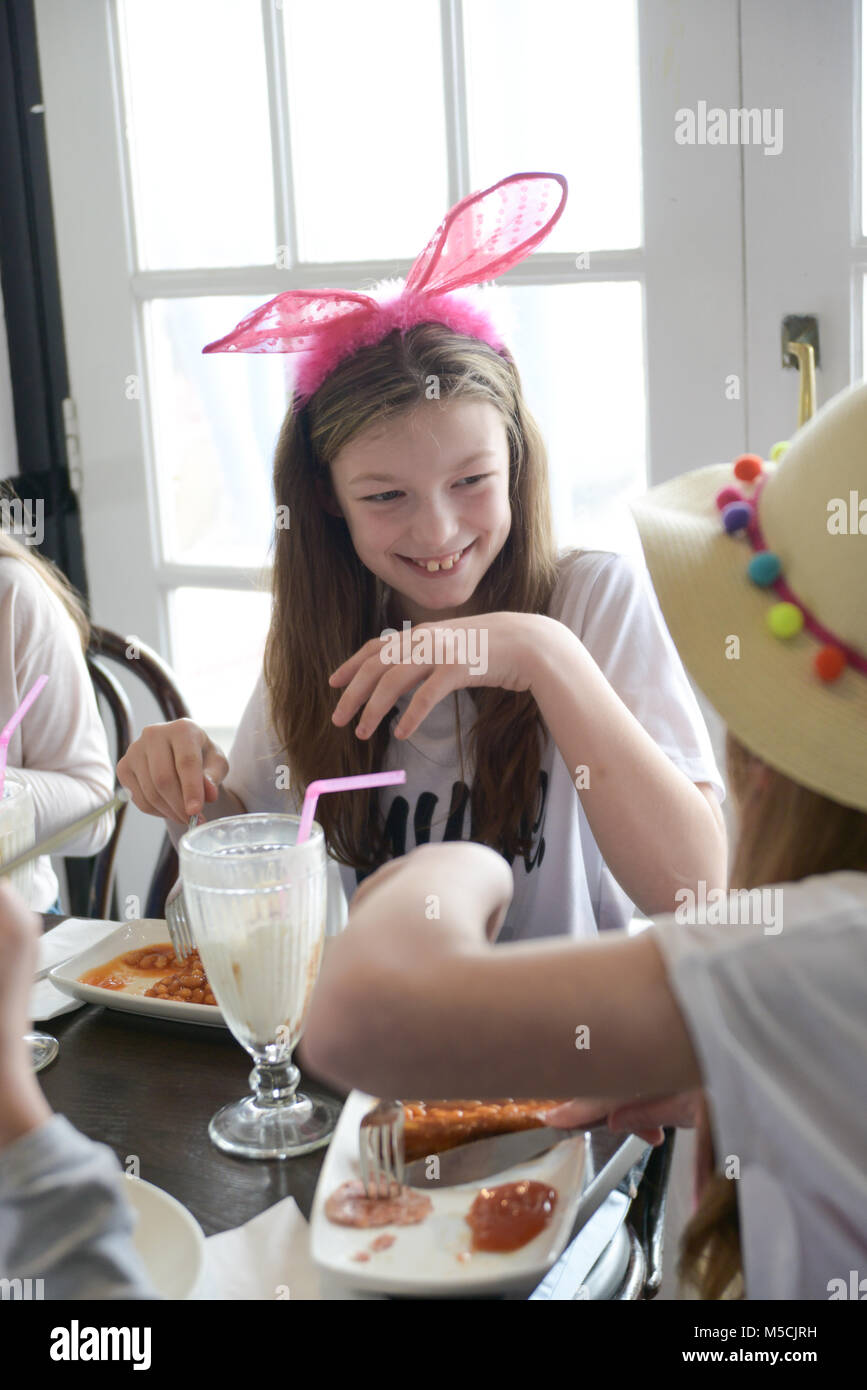 two young children are sitting at a party table eating fried food and ...