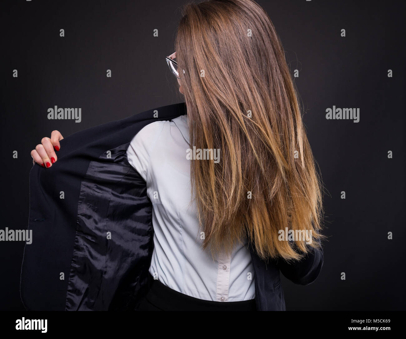 Young caucasian female ceo putting jacket on getting ready for work on ...
