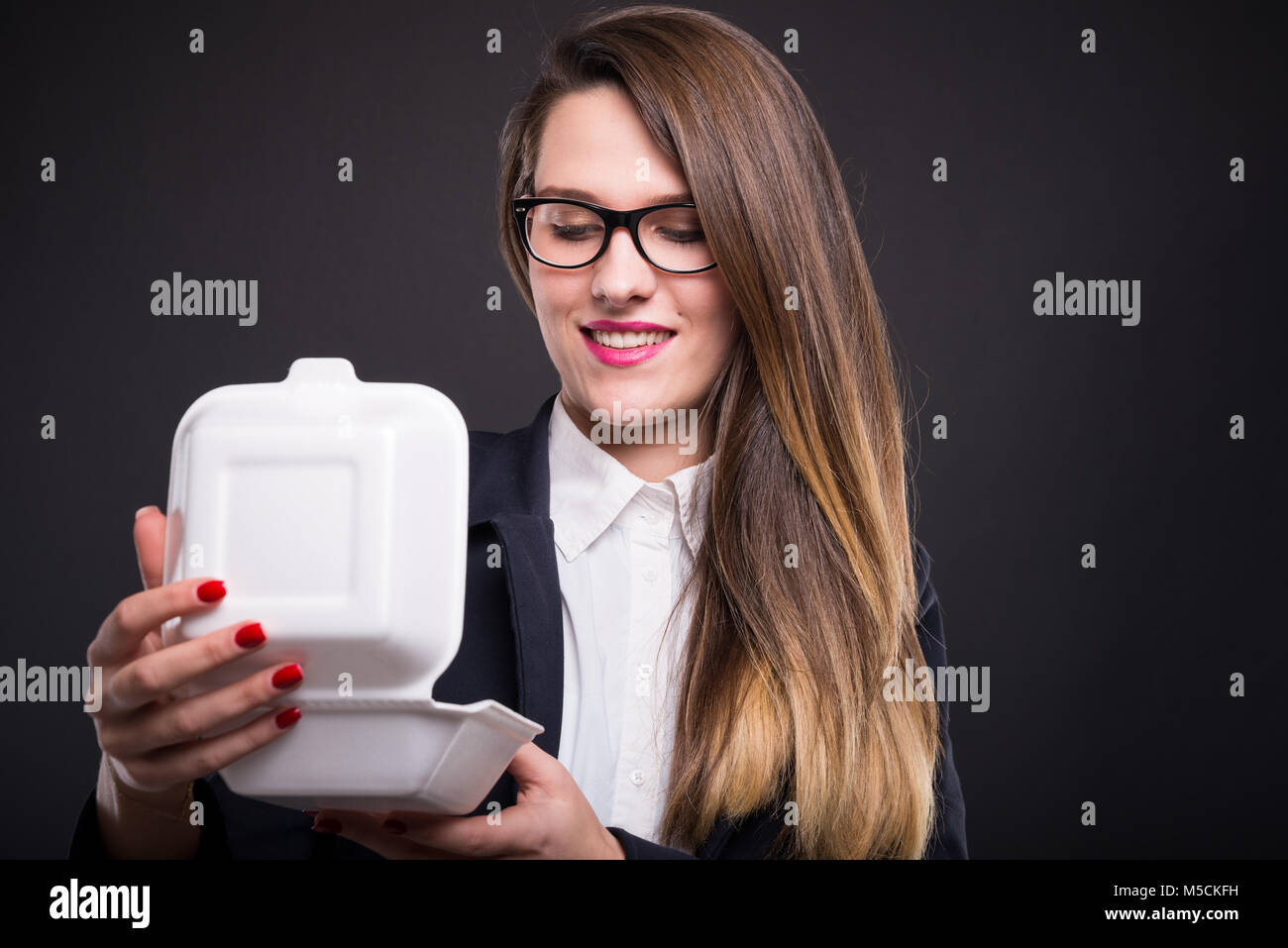 Beautiful young manager enjoying lunch and eating in her break isolated ...