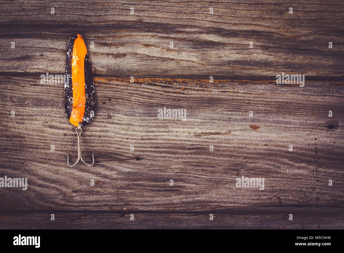 fishing rod with lure over wood background Stock Photo - Alamy