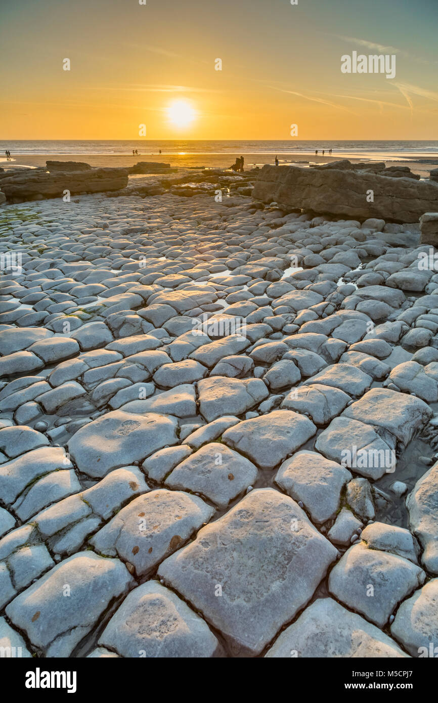 Limestone pavement at Dunraven Bay, Glamorgan, at sunset, with people ...