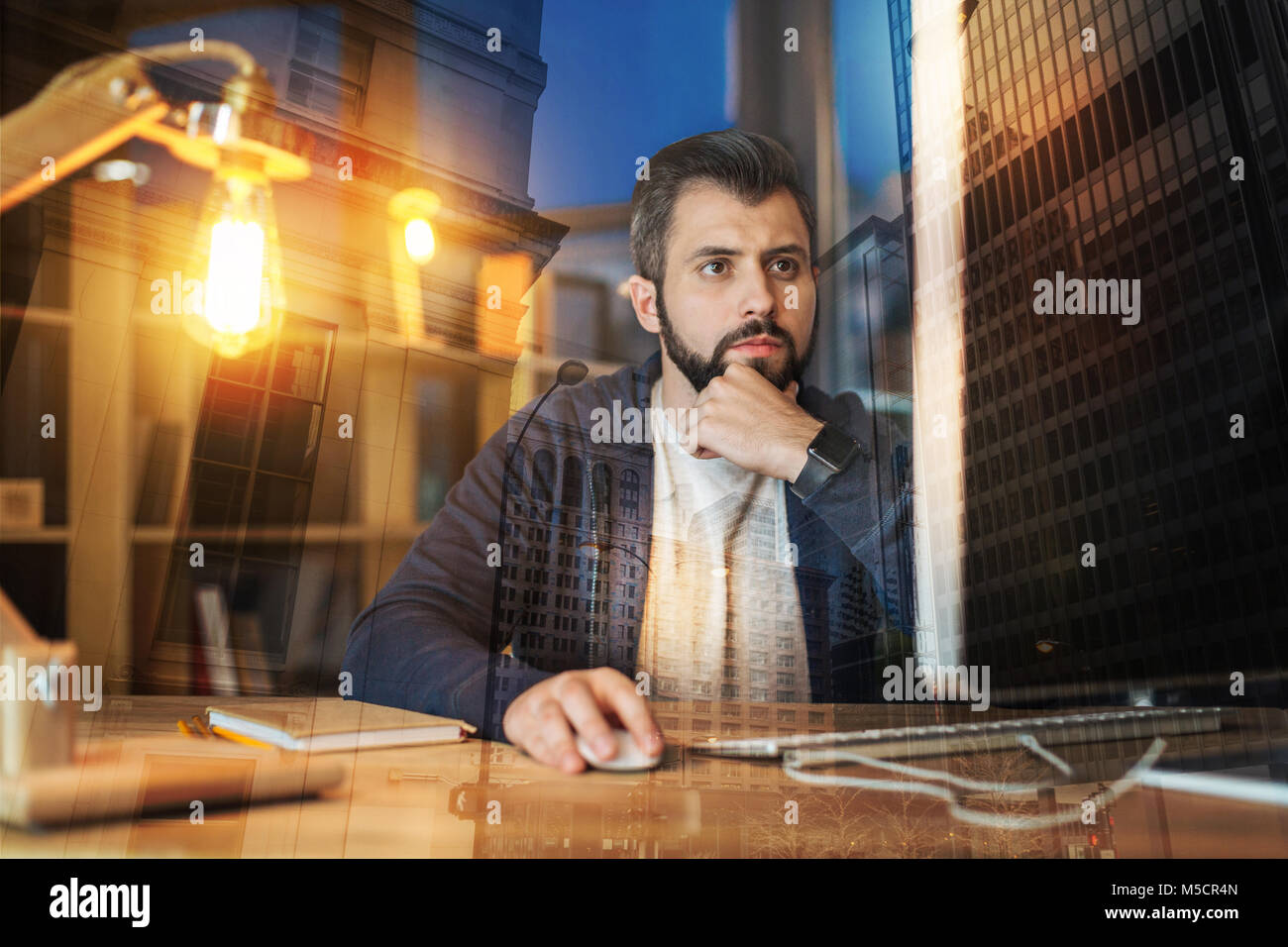 Smart worker thinking while looking at the screen of his computer Stock ...
