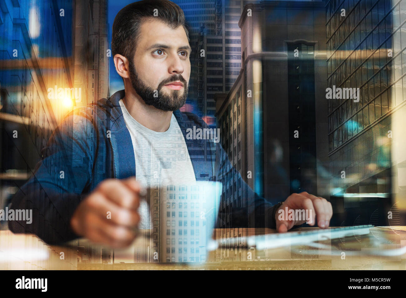 Concentrated man working in his office while drinking tea Stock Photo ...