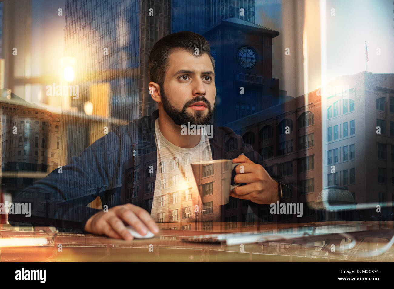 Concentrated man staring at the screen while drinking tea Stock Photo ...
