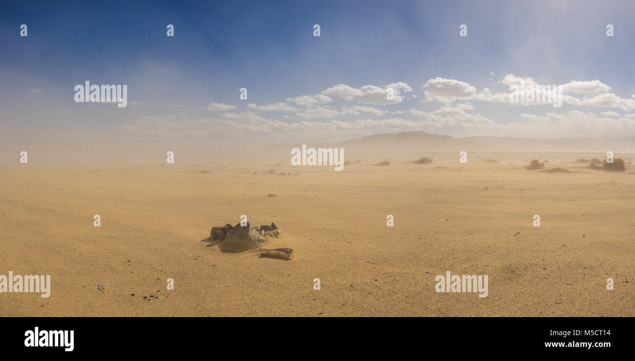 Stone ring forms a fire pit in a vast sand desert under the cloud of a ...