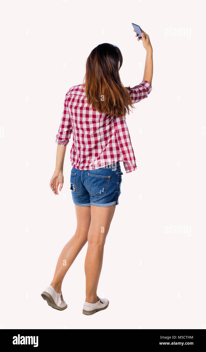 back view of standing young beautiful girl with tablet computer in the ...