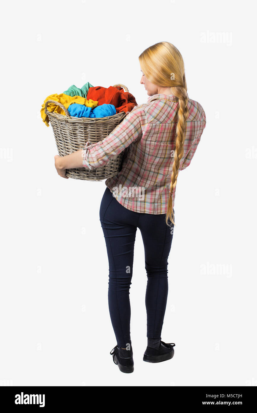 Back view of woman with basket of dirty laundry. girl is engaged in ...