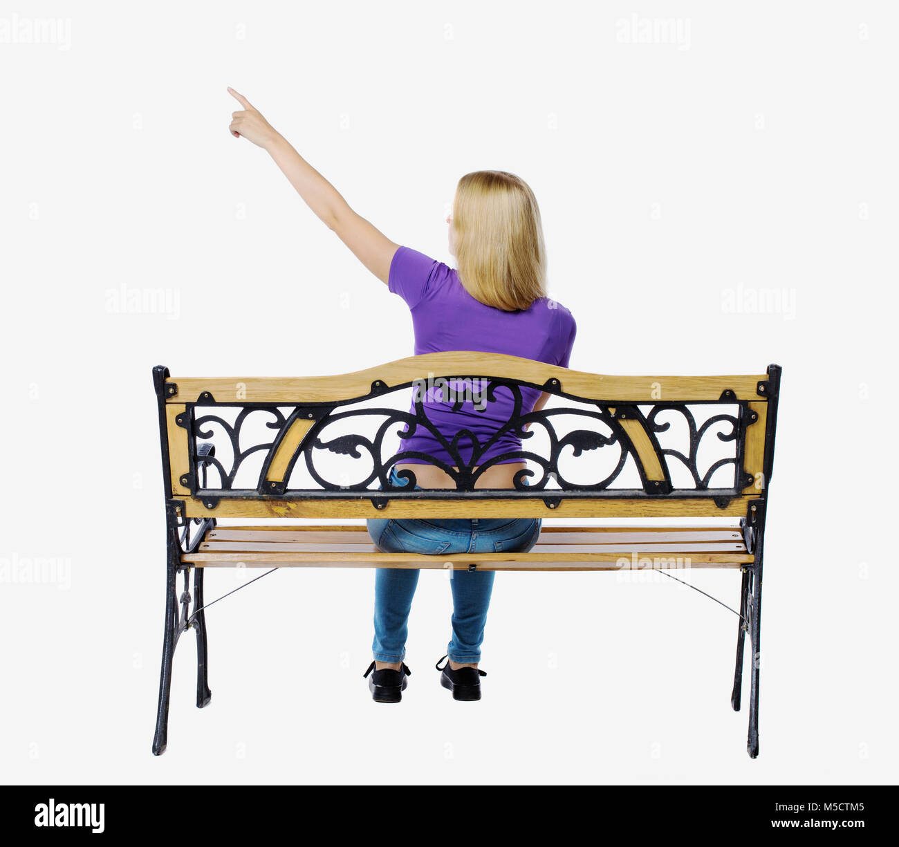 Back view of pointing woman sitting on a bench. girl watching. Rear ...
