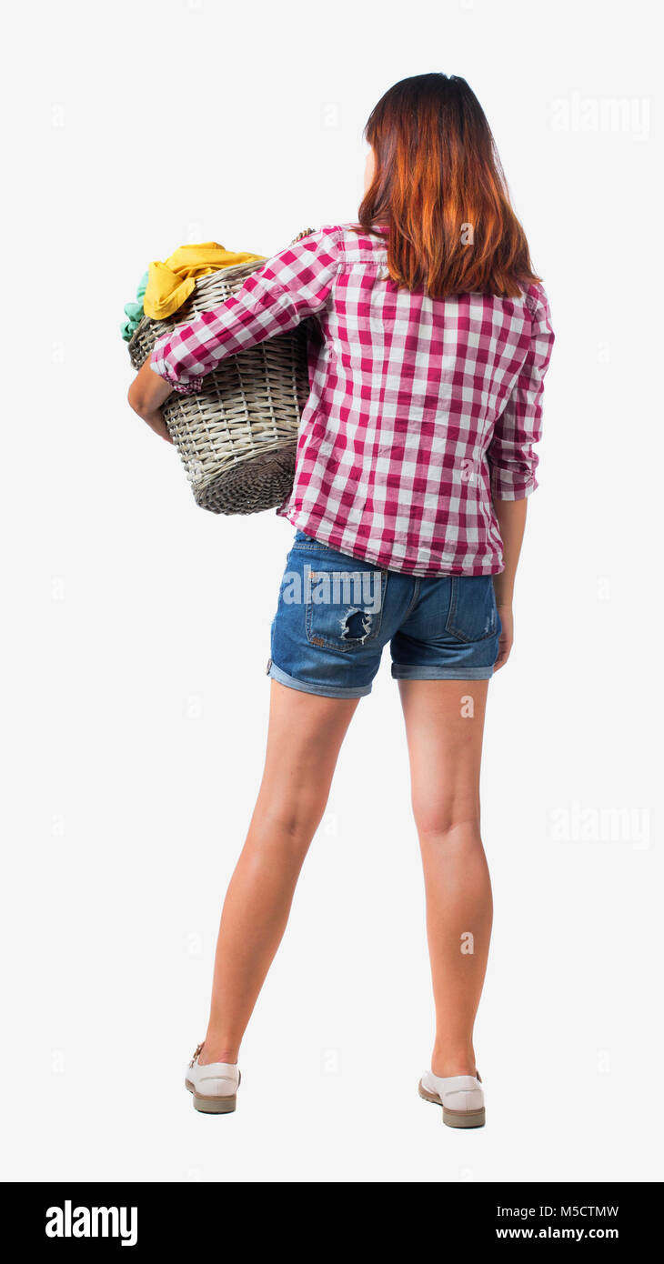 Back view of woman with basket of dirty laundry. girl is engaged in ...