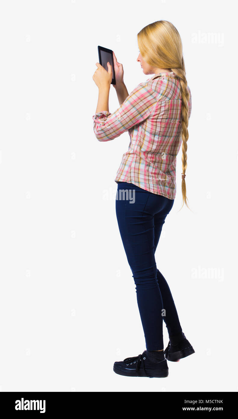 back view of standing young beautiful girl with tablet computer in the ...