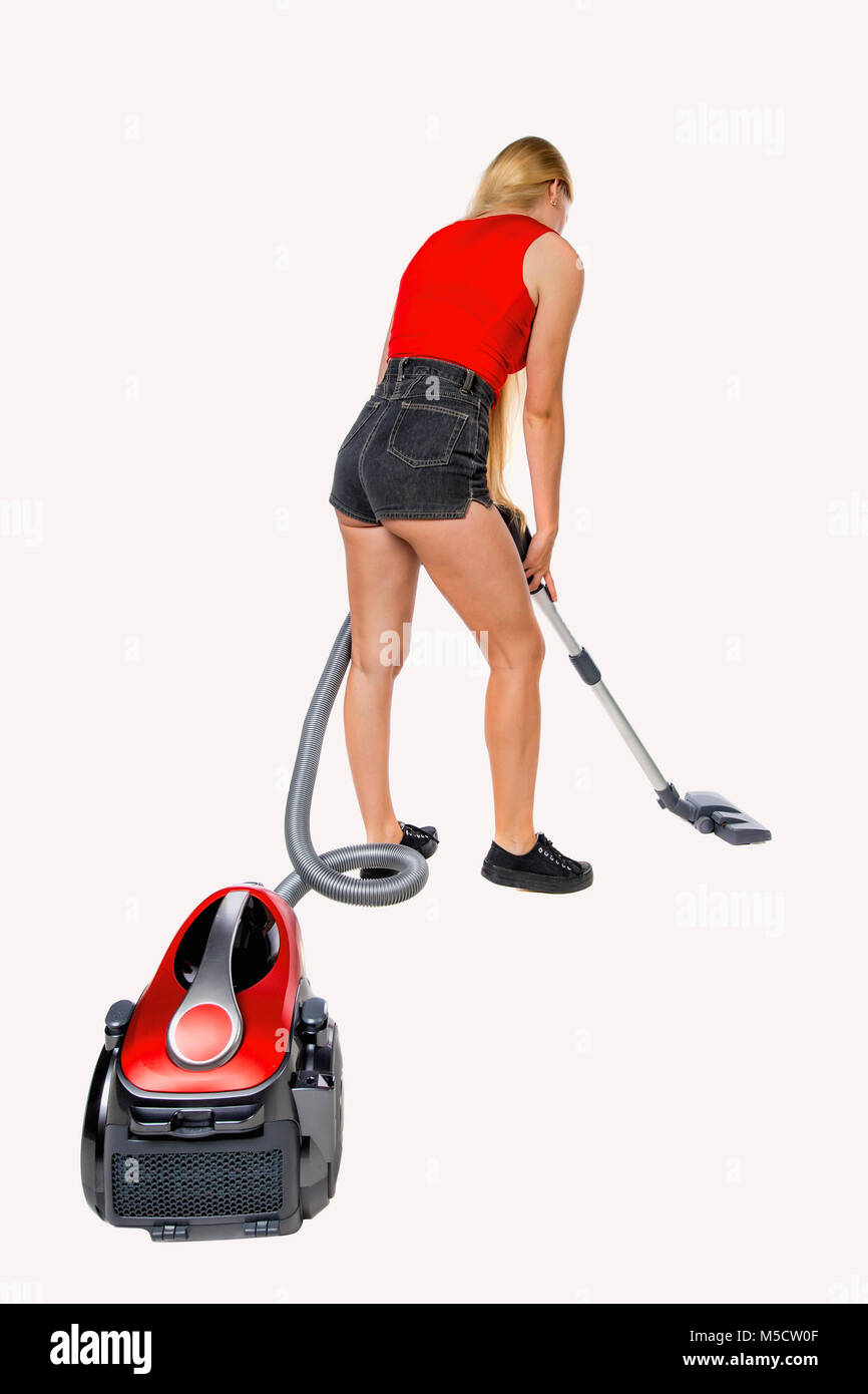 Rear view of a woman with a vacuum cleaner. She is busy cleaning. Rear ...
