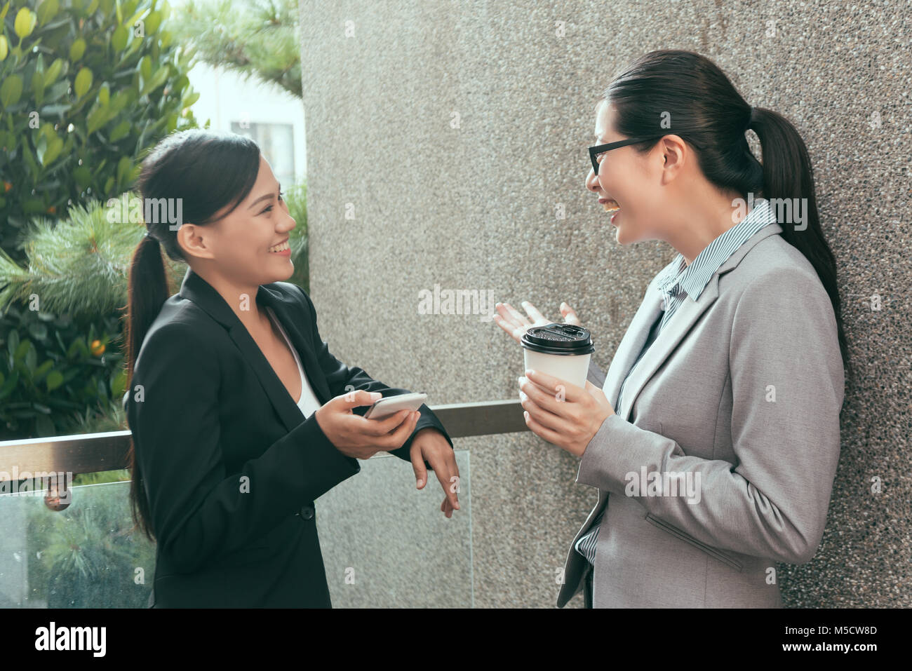 beautiful Asian women chatting together, talking about office rumor and ...