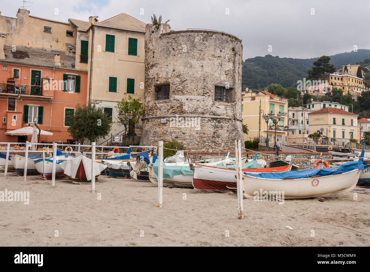 The sixteenth-century tower and the fishing boats on the beach of ...