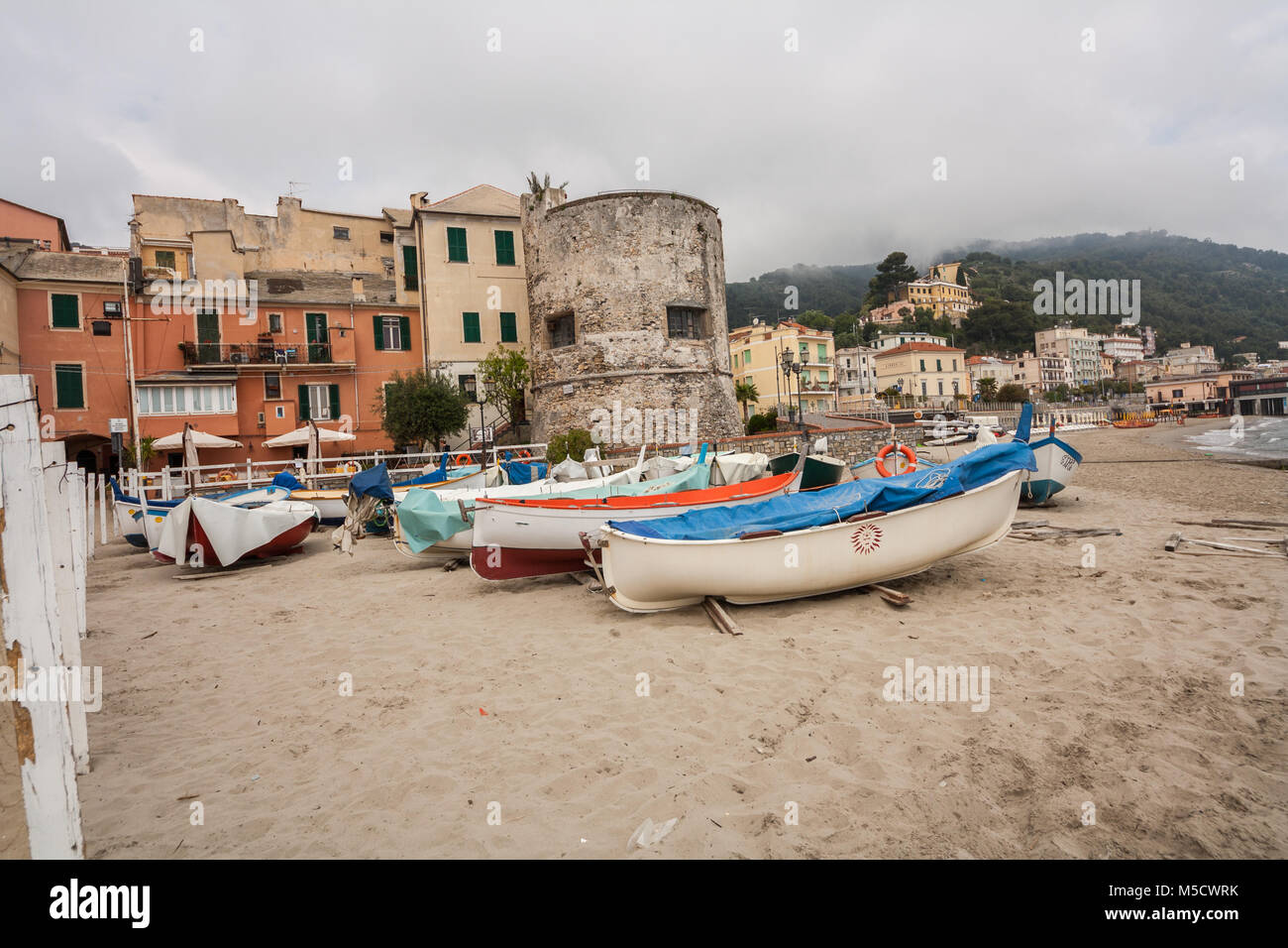 The sixteenth-century tower and the fishing boats on the beach of ...