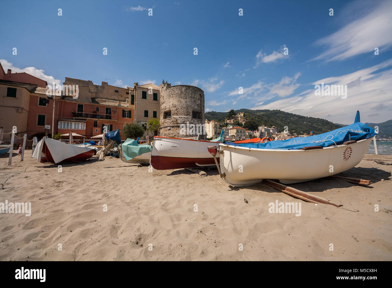 The sixteenth-century tower and the fishing boats on the beach of ...