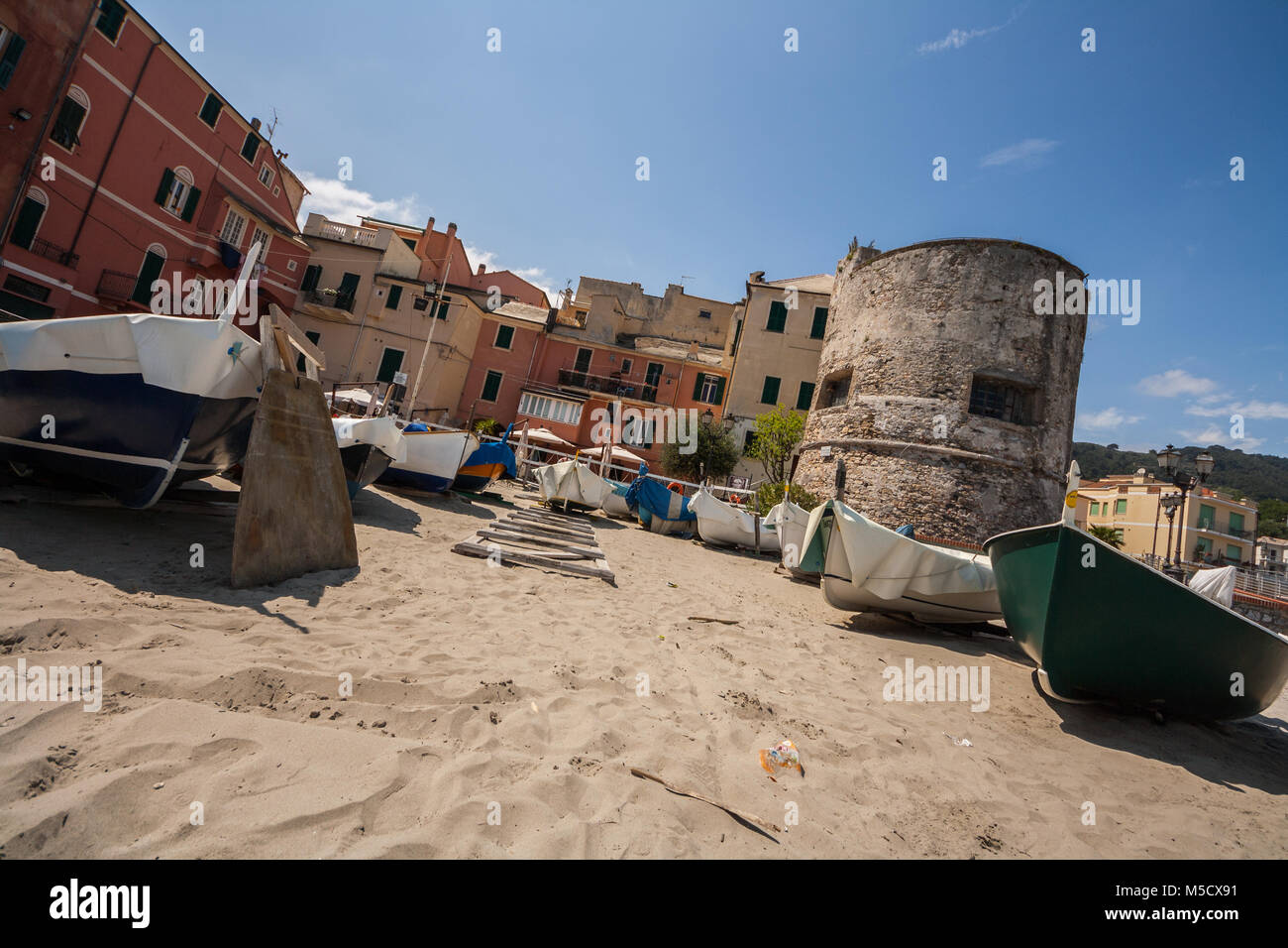The sixteenth-century tower and the fishing boats on the beach of ...