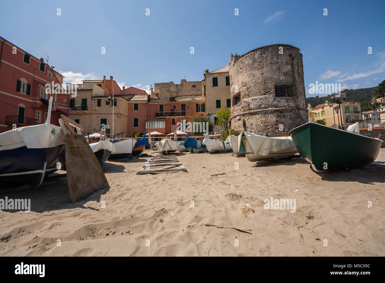 The sixteenth-century tower and the fishing boats on the beach of ...