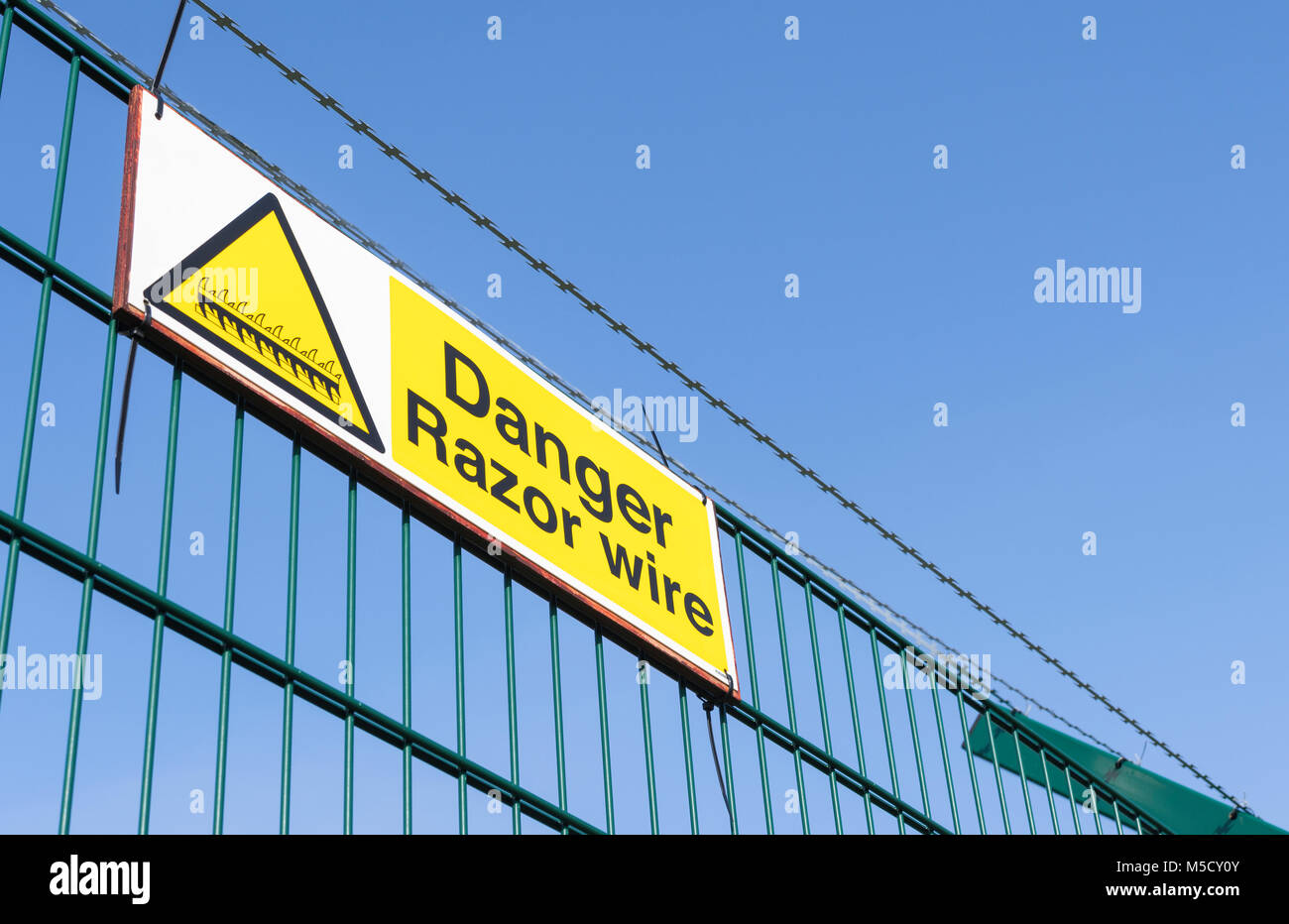 Danger Razor Wire warning sign on top of a security fence in the UK ...