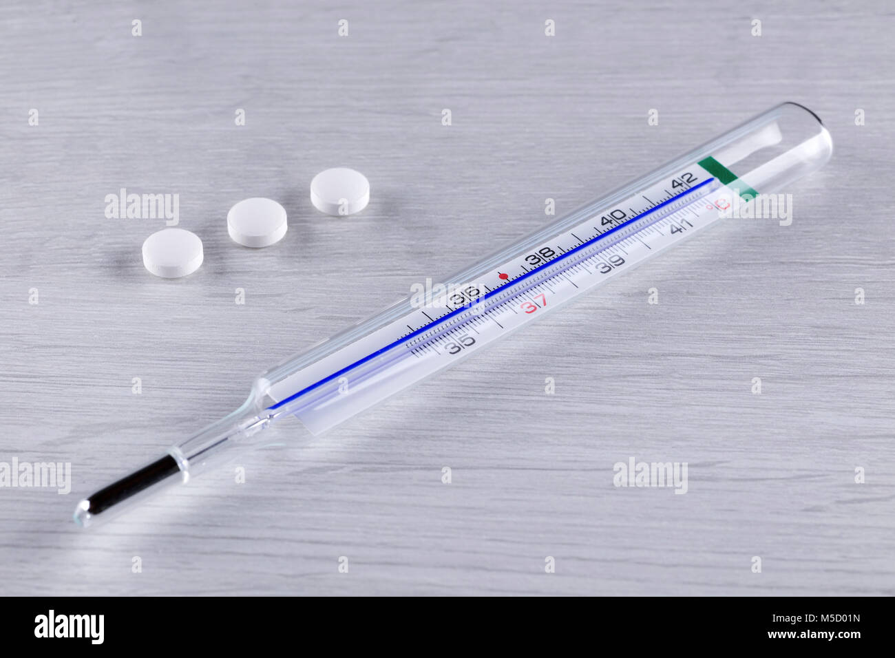 Tablets and a medical thermometer showing a high temperature Stock ...