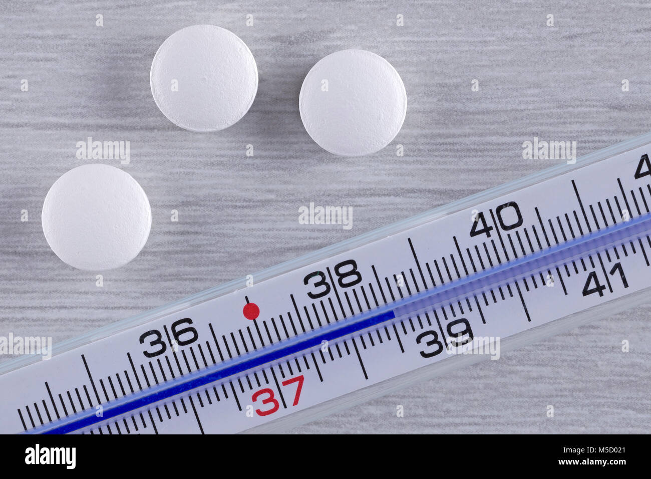 Tablets and a detail of a medical thermometer showing a high ...