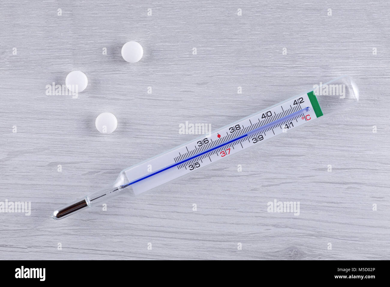 Tablets and a medical thermometer showing a high temperature Stock ...