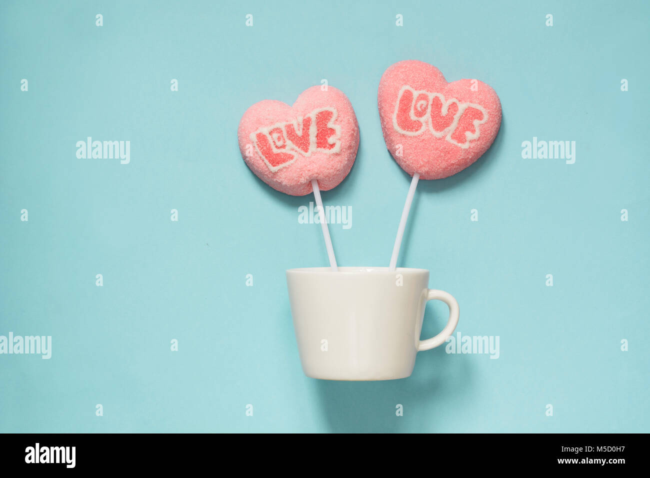 Couple lollipops pink candy on stick with Love text on blue background ...