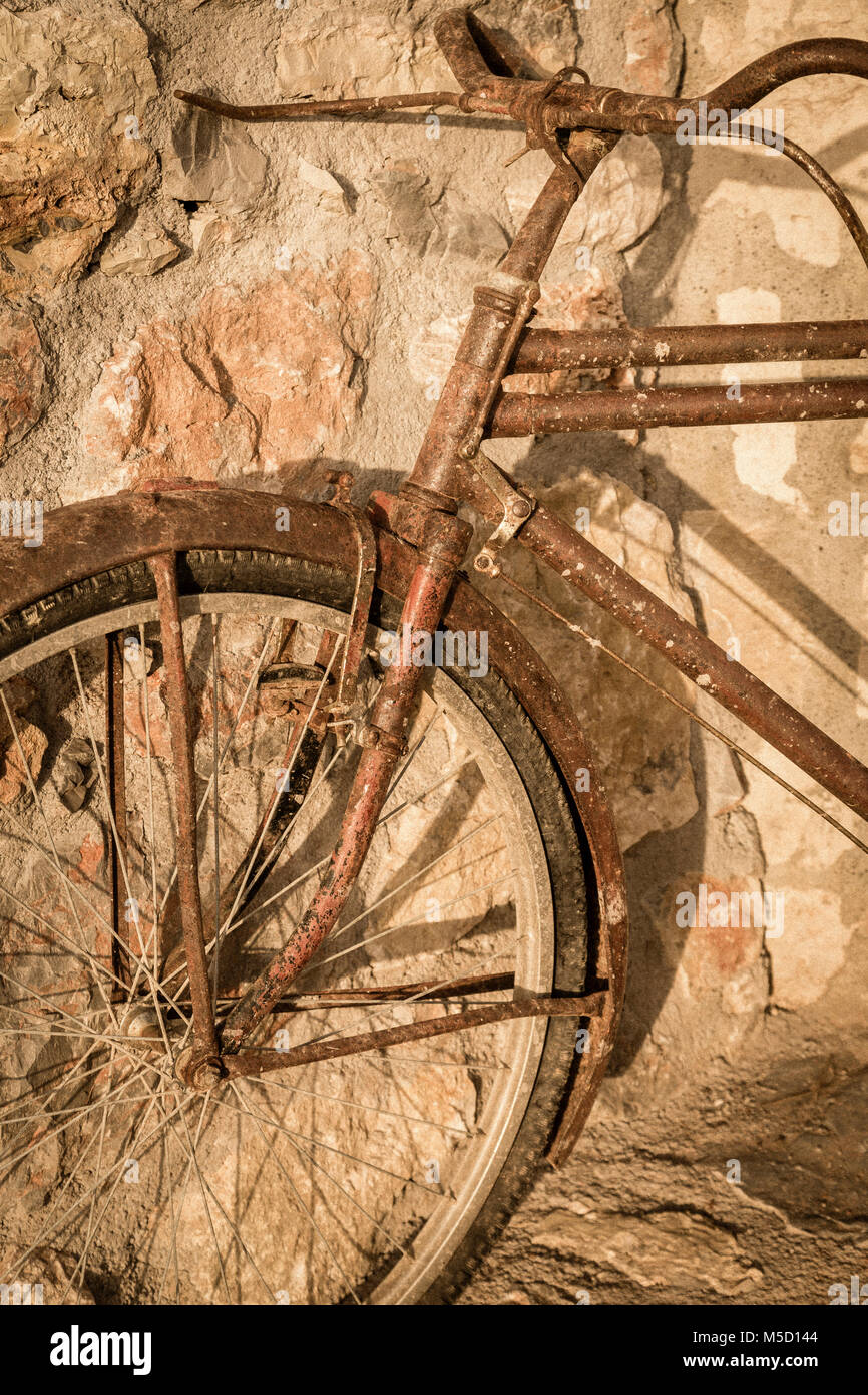 Rusty old bicycle leaning against a stone wall, Crete Stock Photo - Alamy