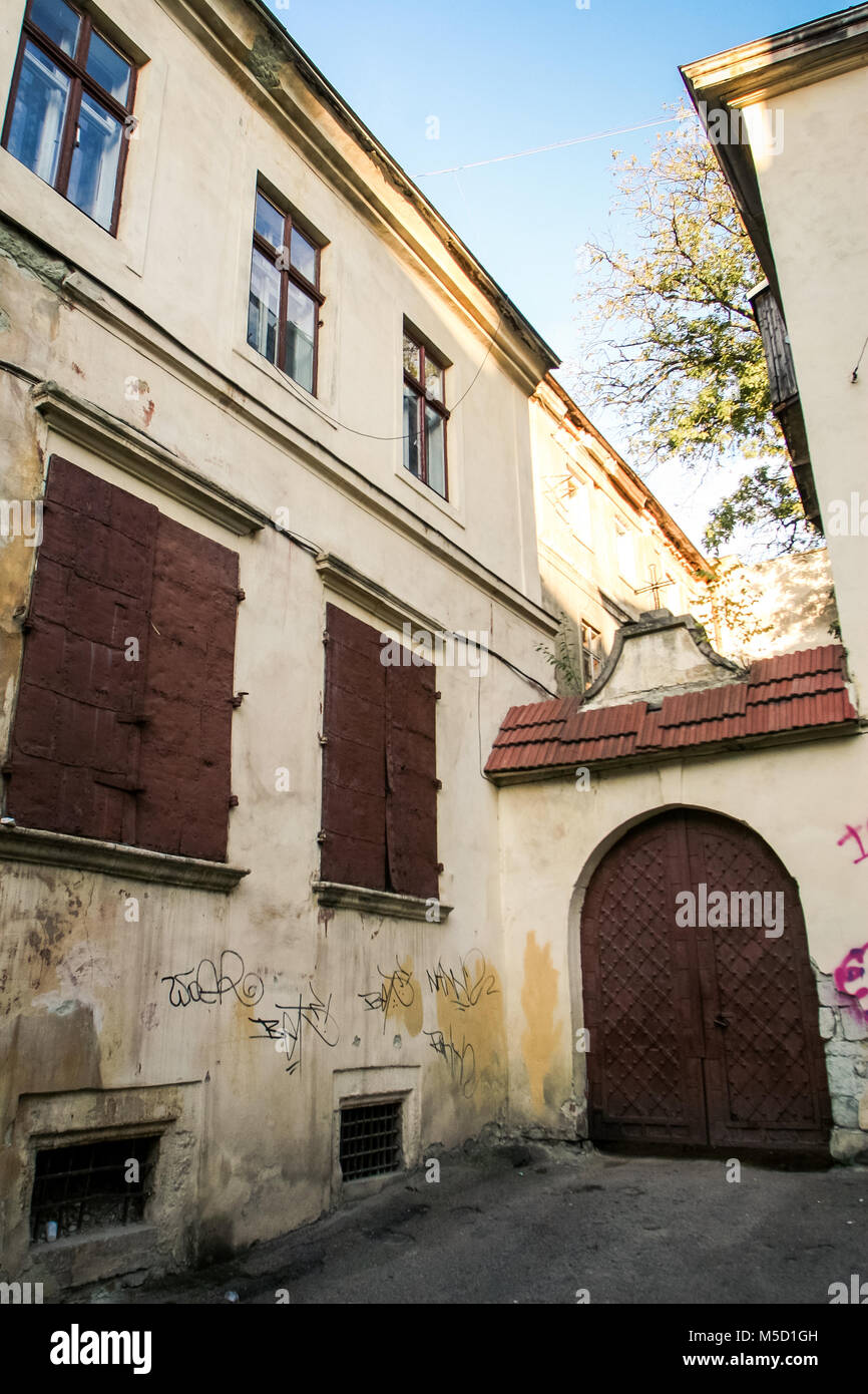 monastery yard with old iron door under roof with cross and building ...