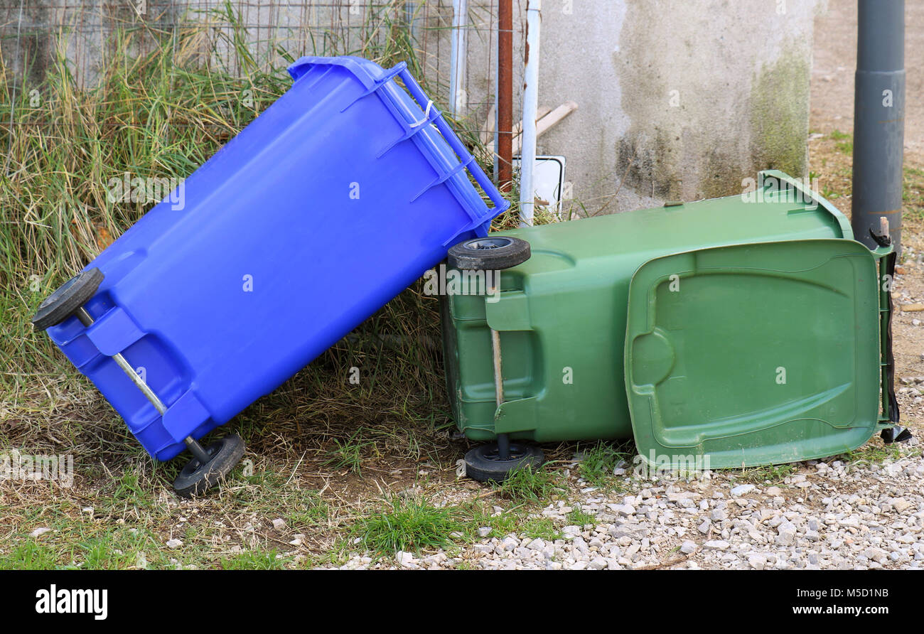 Classic plastic garbage bins with open lid knocked down outdoor Stock ...