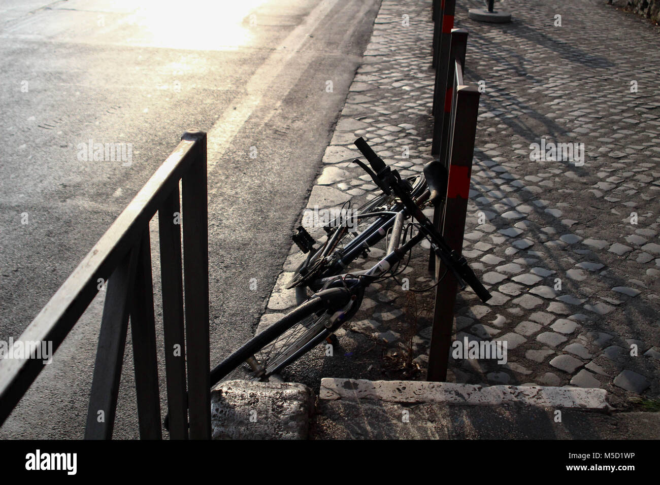 A bicycle resting on a gate, by the road leading to the Roman Colosseum ...