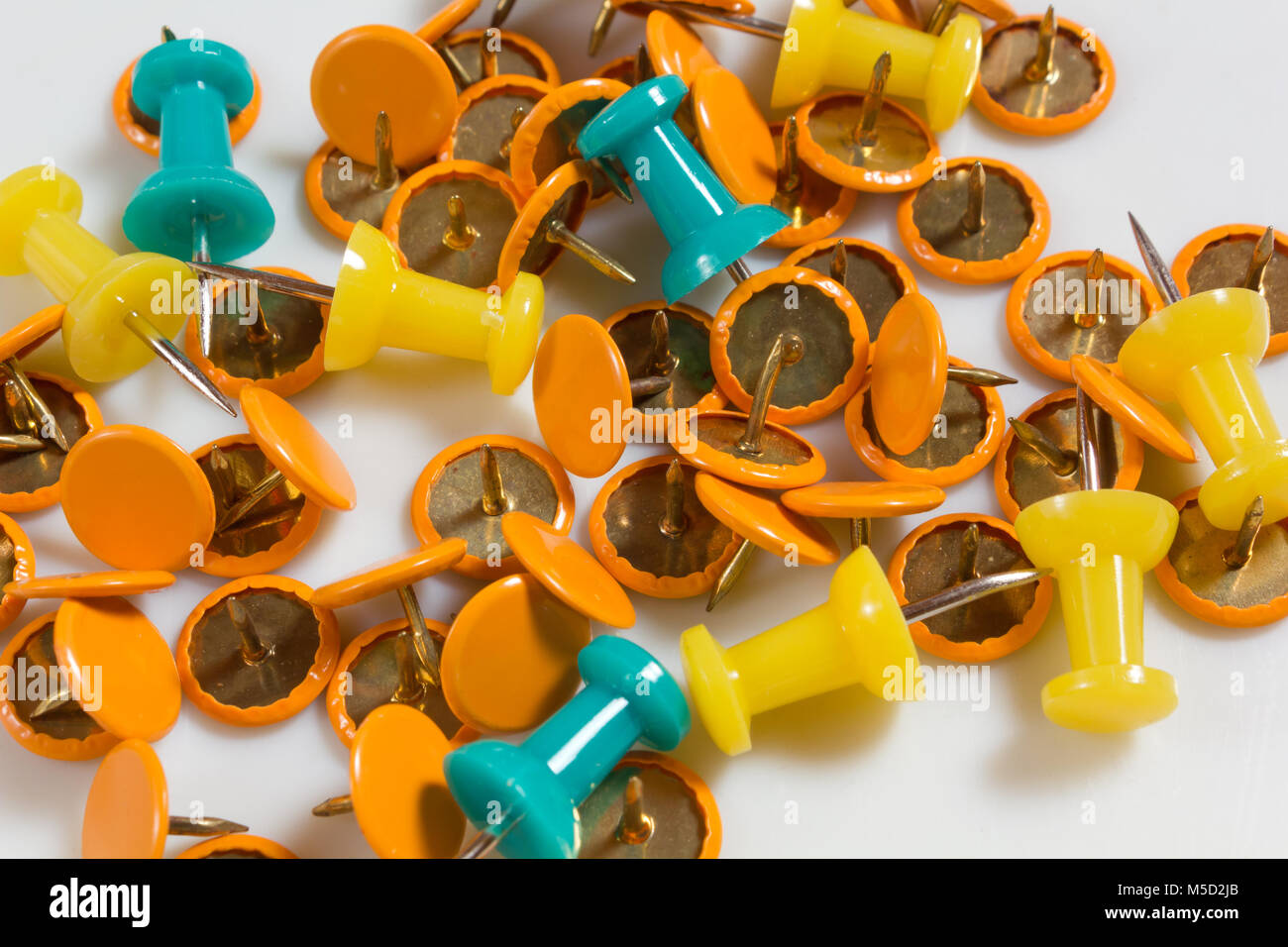 Colored pushpins scattered accross a white background Stock Photo - Alamy