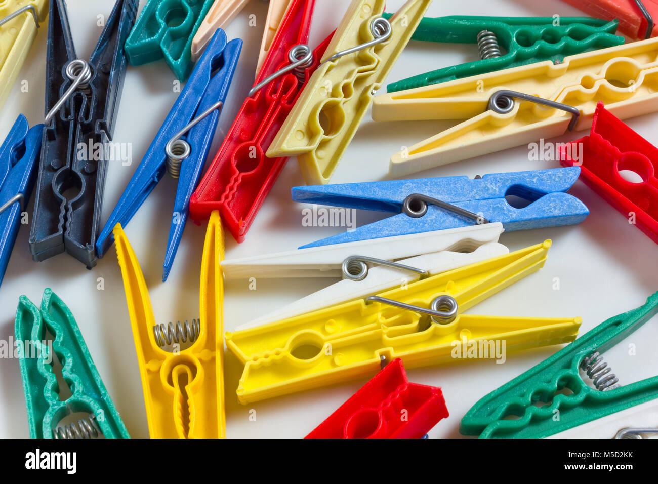 Clothespins of different shapes, sizes and colours scatered across a ...