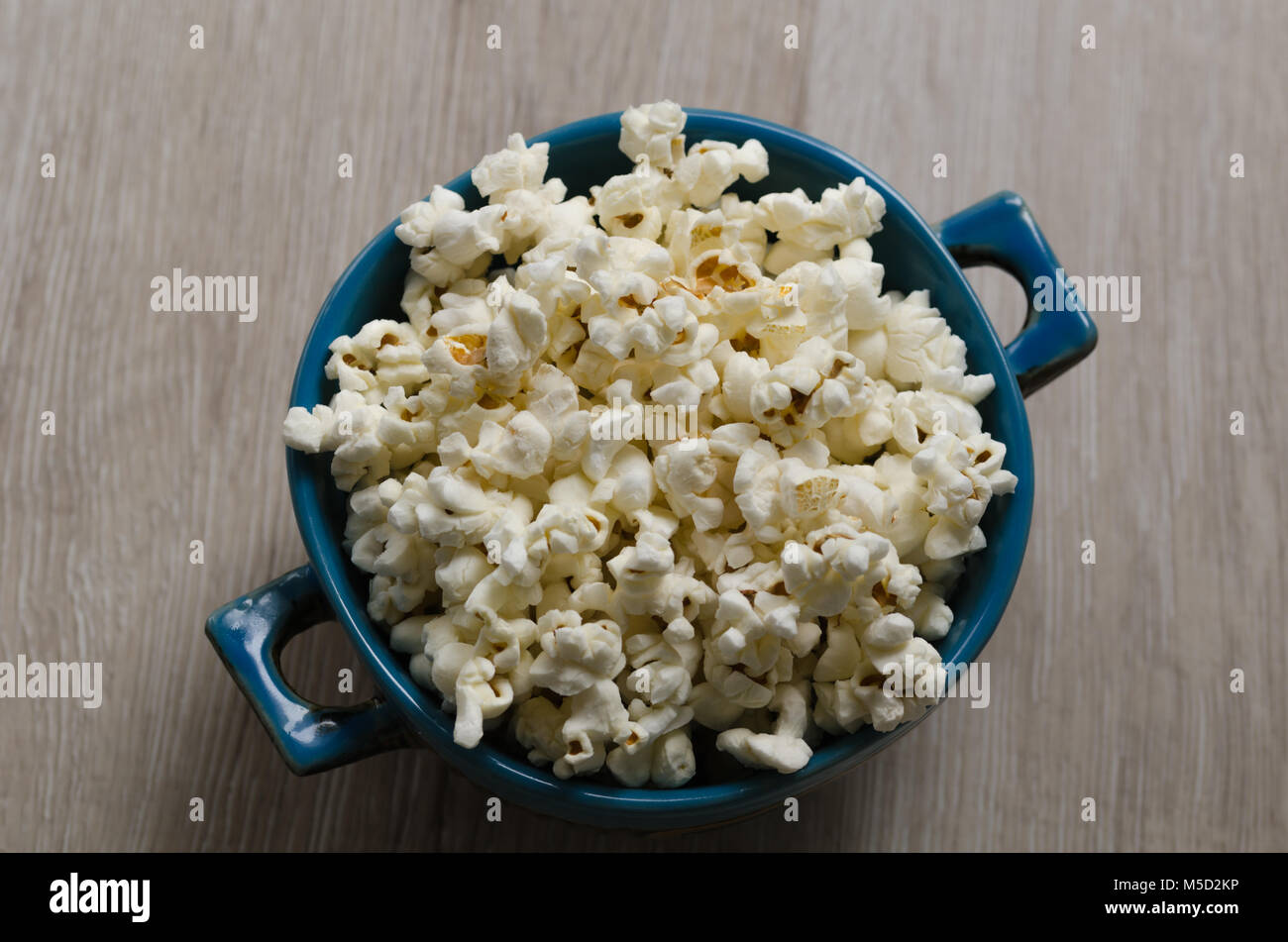 Popcorn in the blue bowl. Top view Stock Photo - Alamy