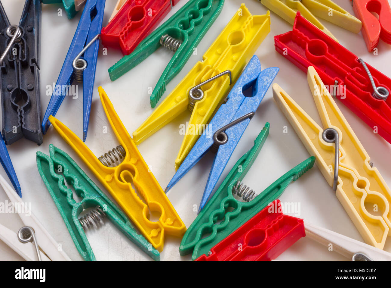 Clothespins of different shapes, sizes and colours scatered across a ...
