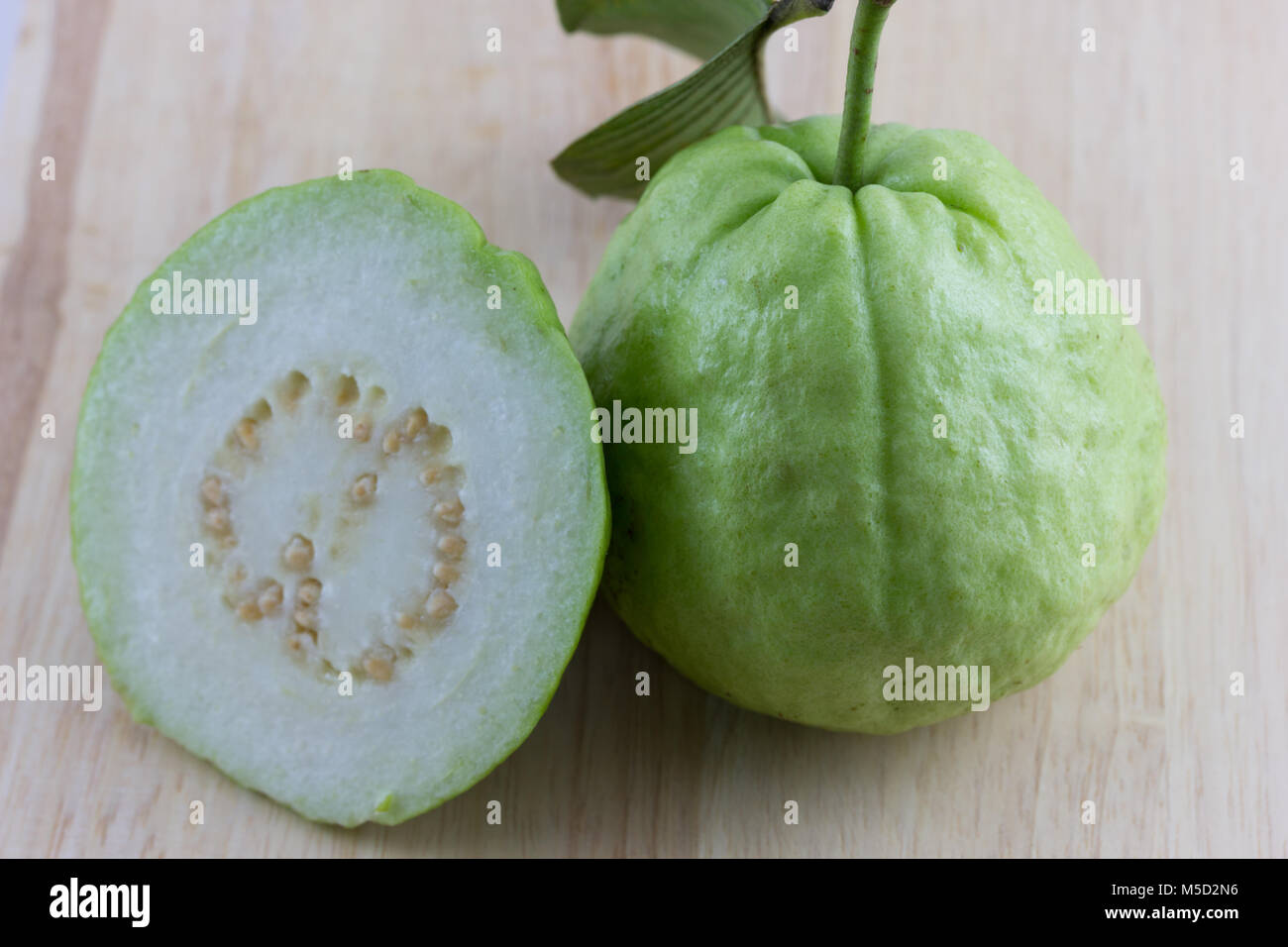 Half guava and slices with the complete one on white background Stock ...