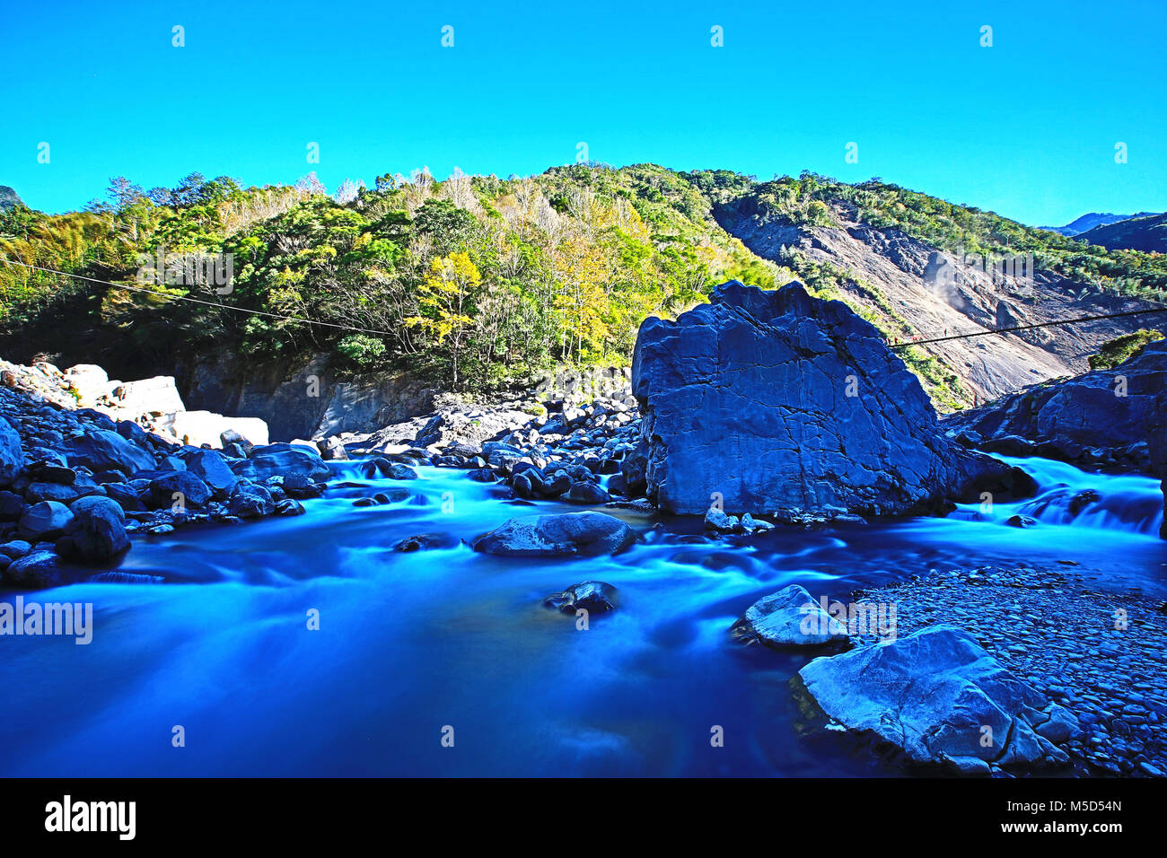 Beautiful flowing river landscape with rocks and trees among the ...