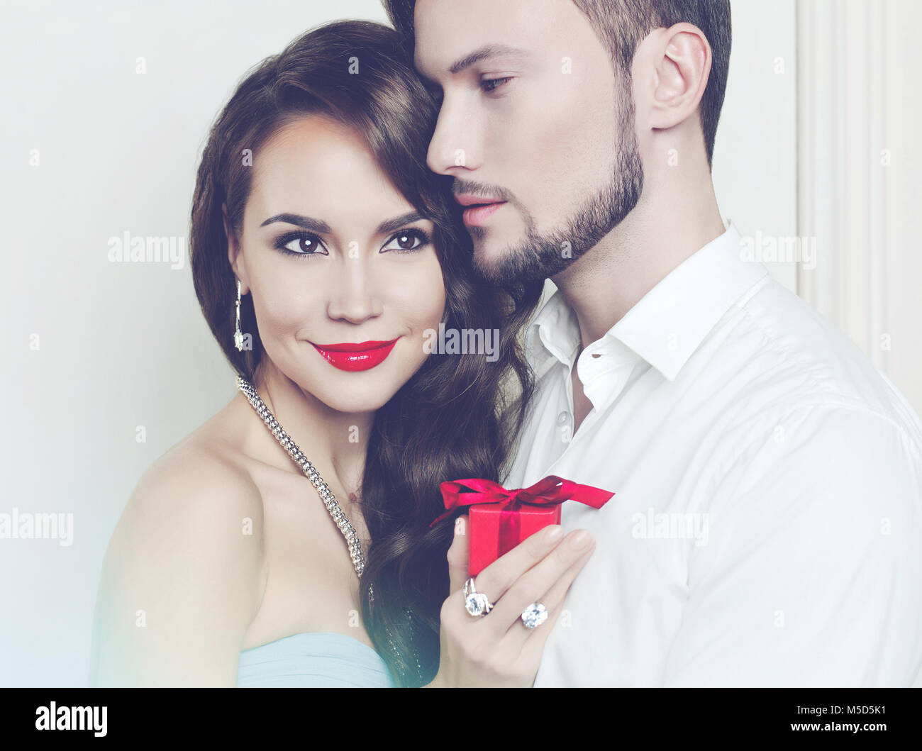 Fashion photo of beautiful romantic couple with gift Stock Photo - Alamy