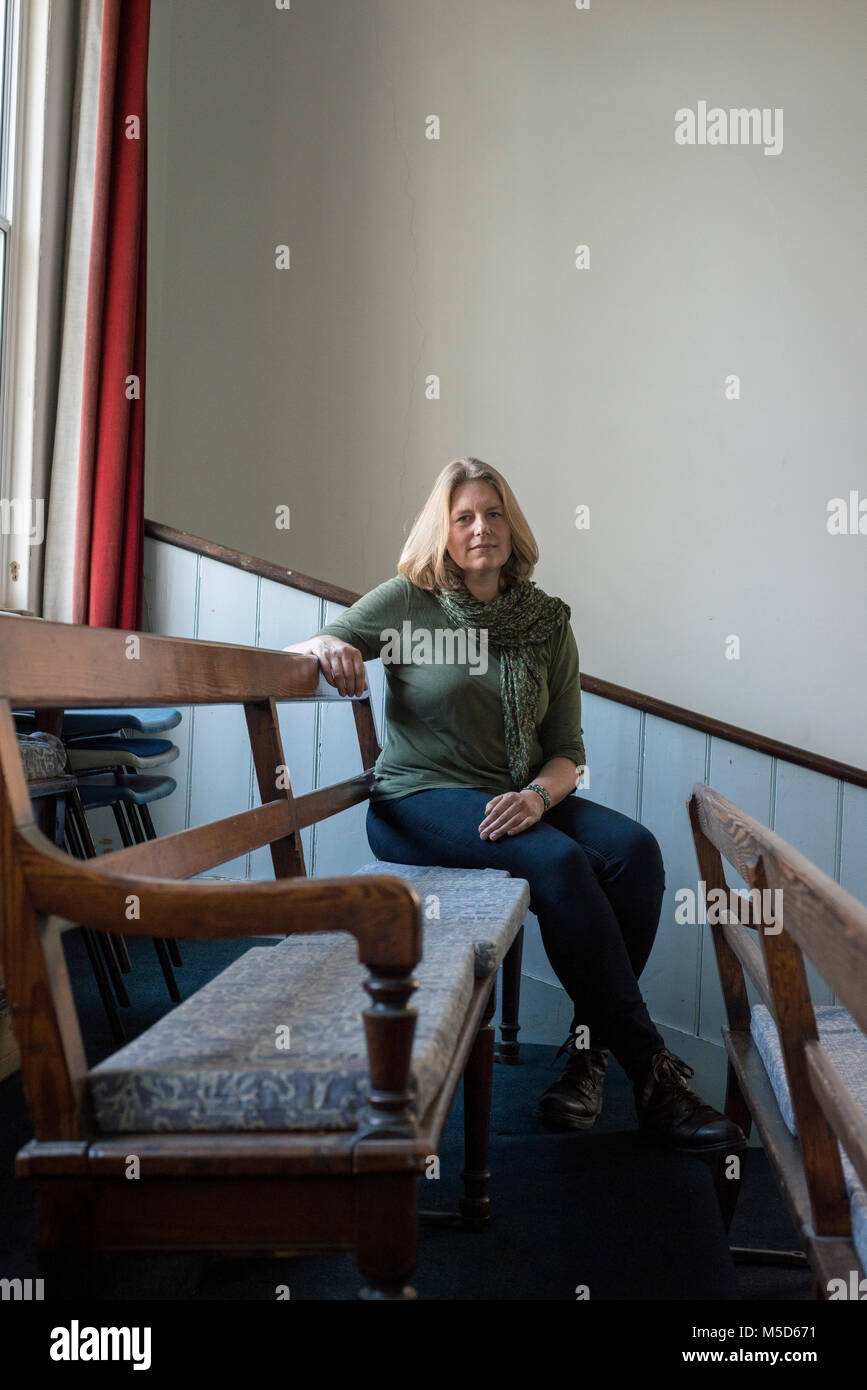a female quaker preacher sits on the pews in the meeting house in ...