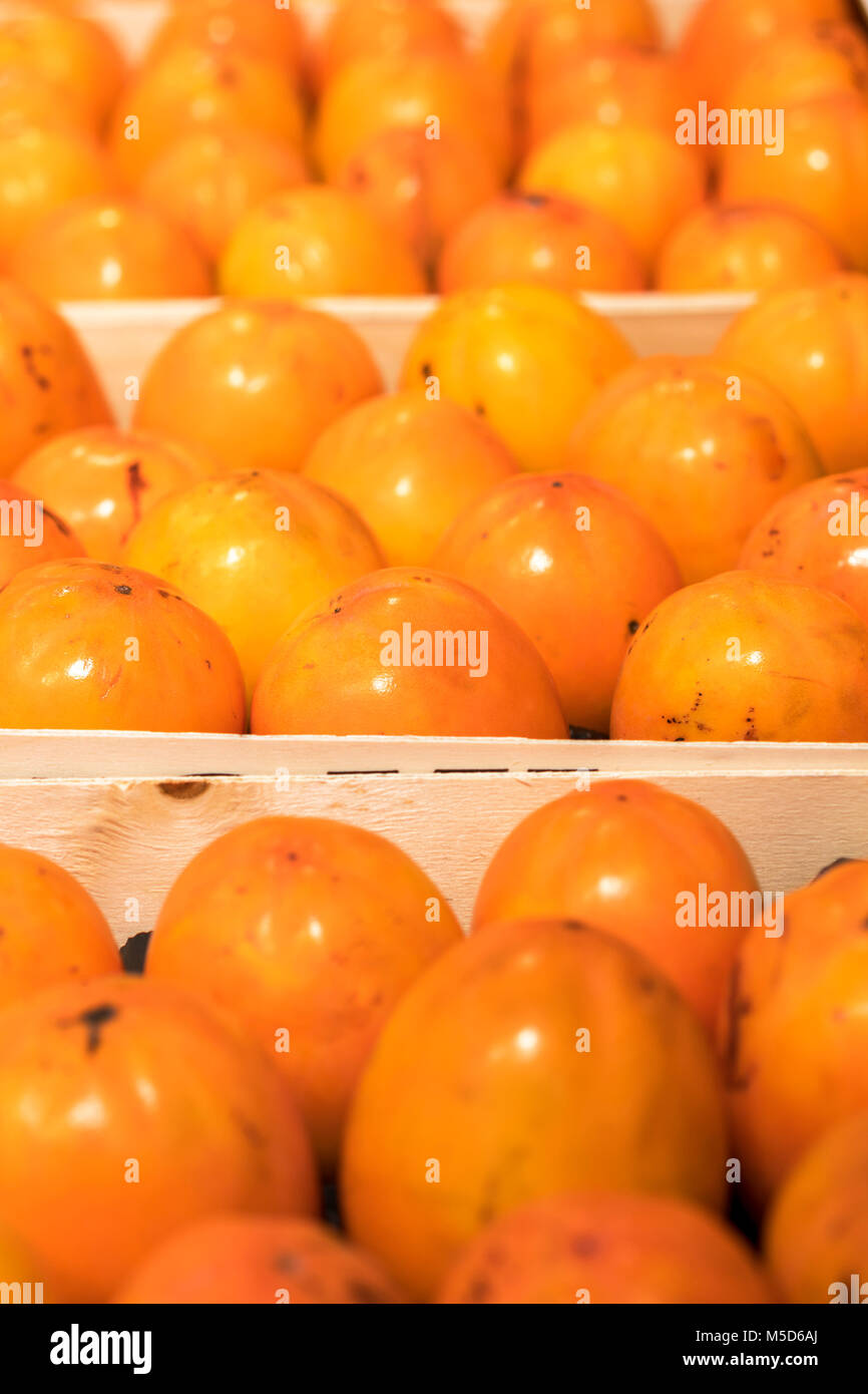 Ripe persimmon in wooden boxes. close-up Stock Photo - Alamy