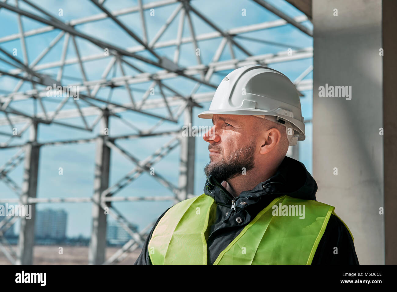 Builder in a helmet on construction object Stock Photo - Alamy