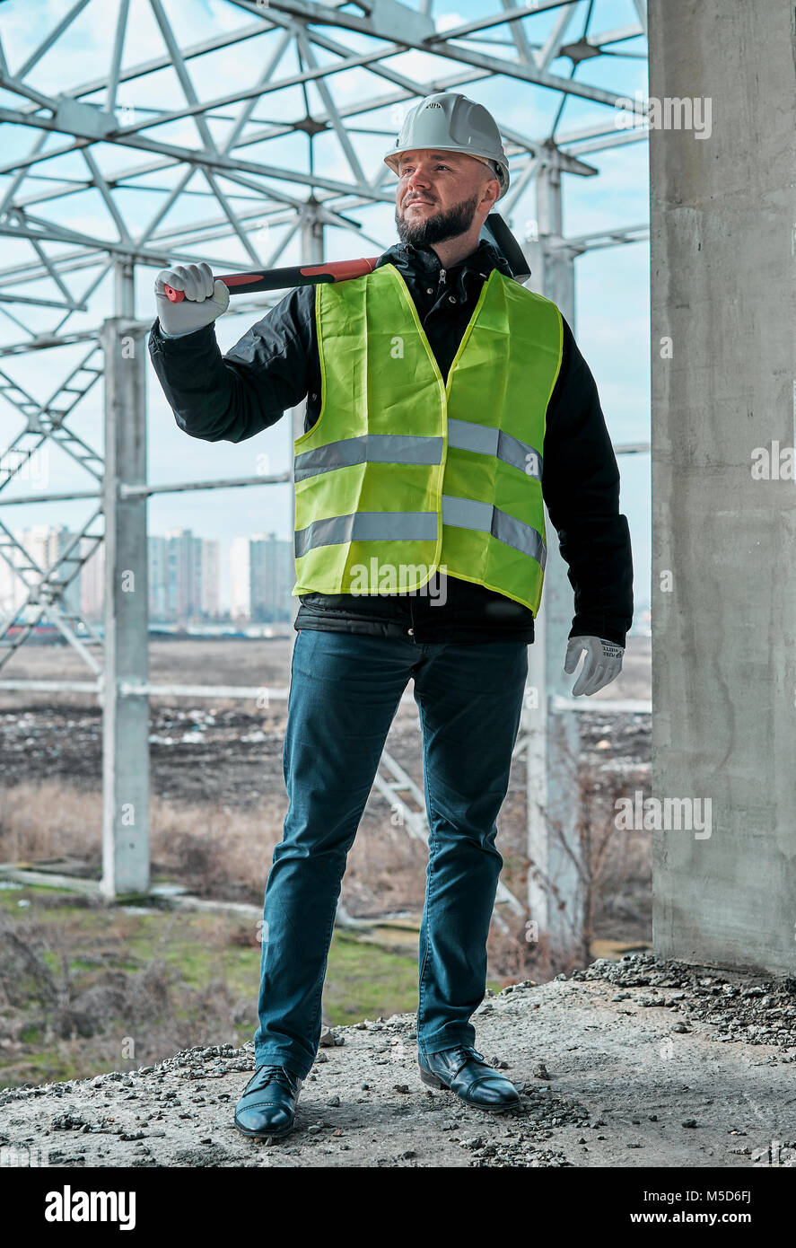 Builder in a helmet on construction object Stock Photo - Alamy