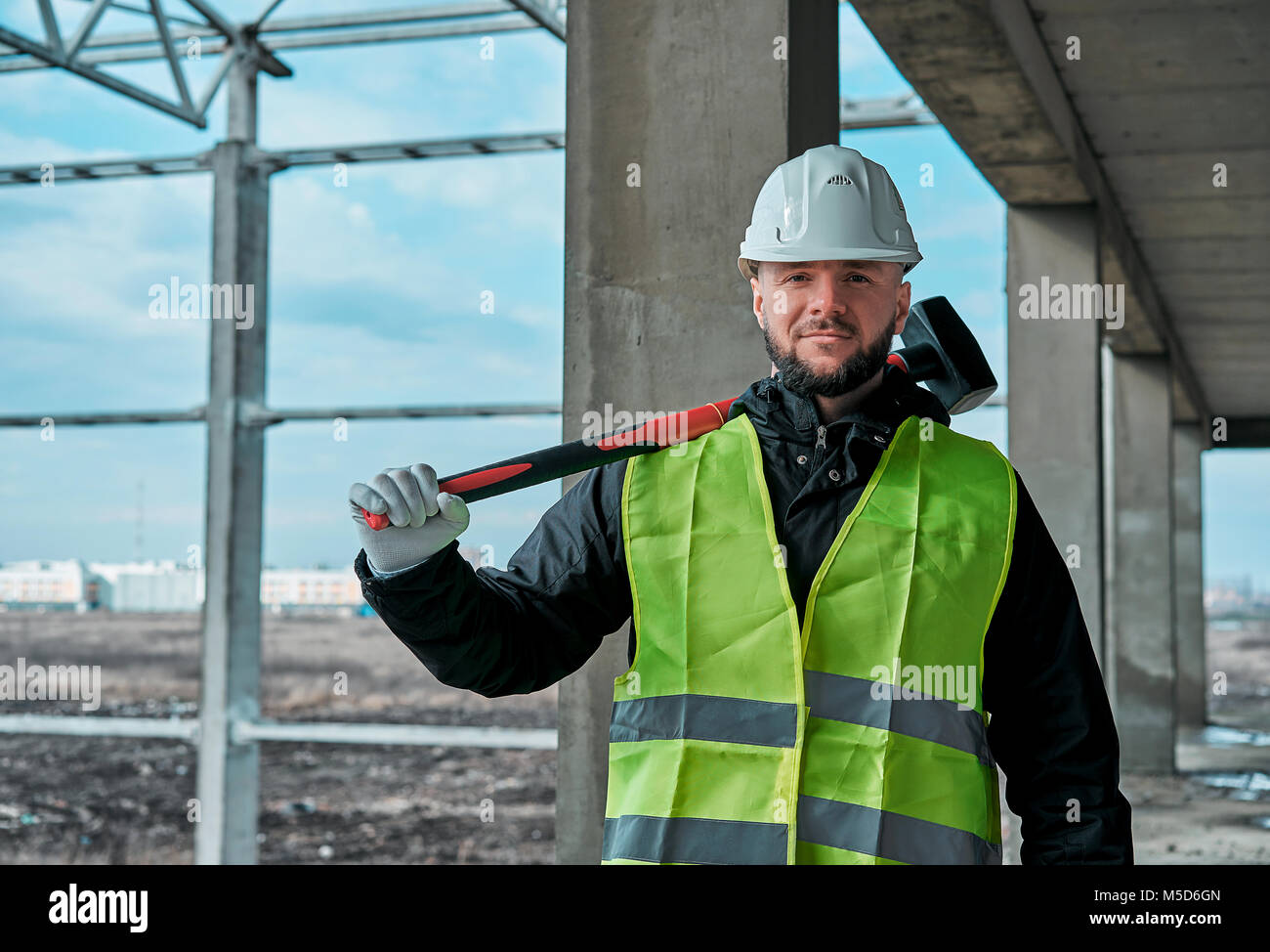 Builder in a helmet on construction object Stock Photo - Alamy