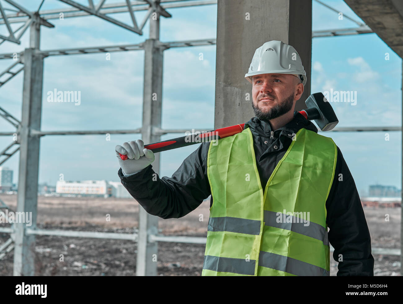 Builder in a helmet on construction object Stock Photo - Alamy
