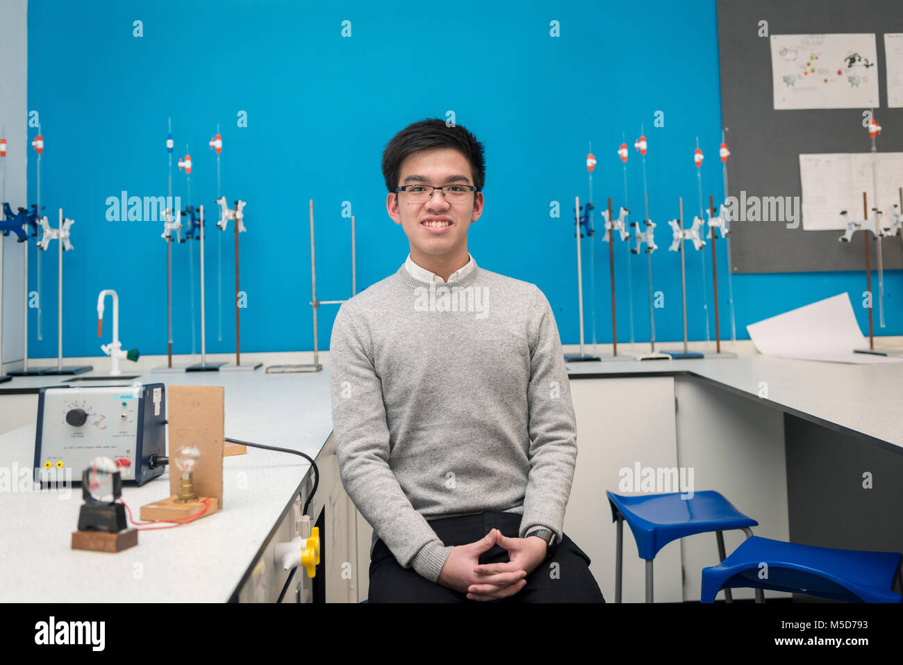 a smart young asian student sits in the science lab of a college Stock ...