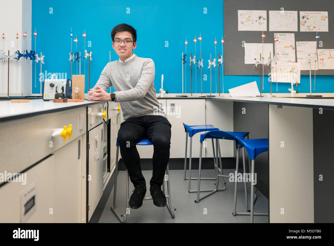 a smart young asian student sits in the science lab of a college Stock ...