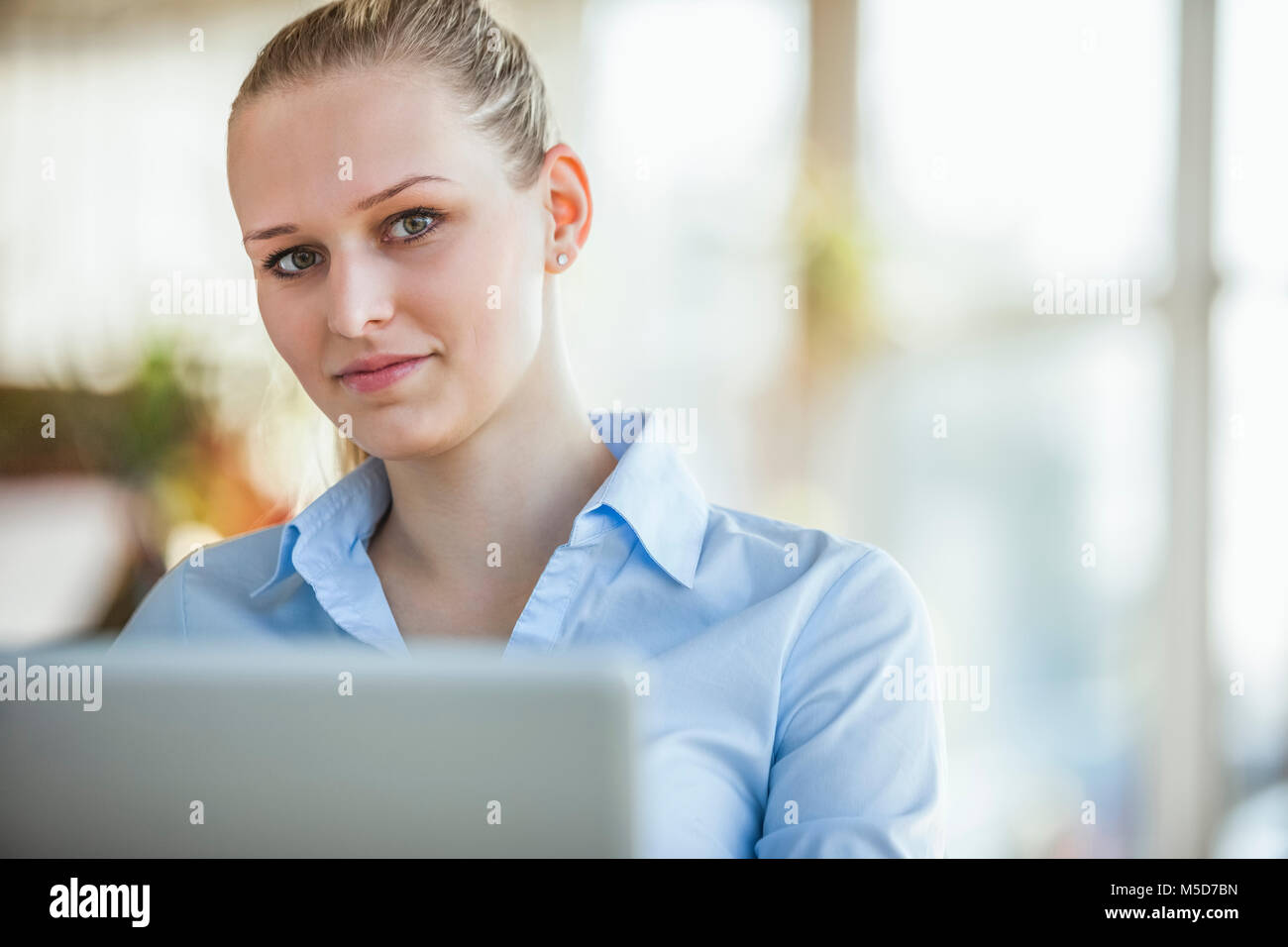 Portrait of confident young businesswoman with laptop in office Stock ...