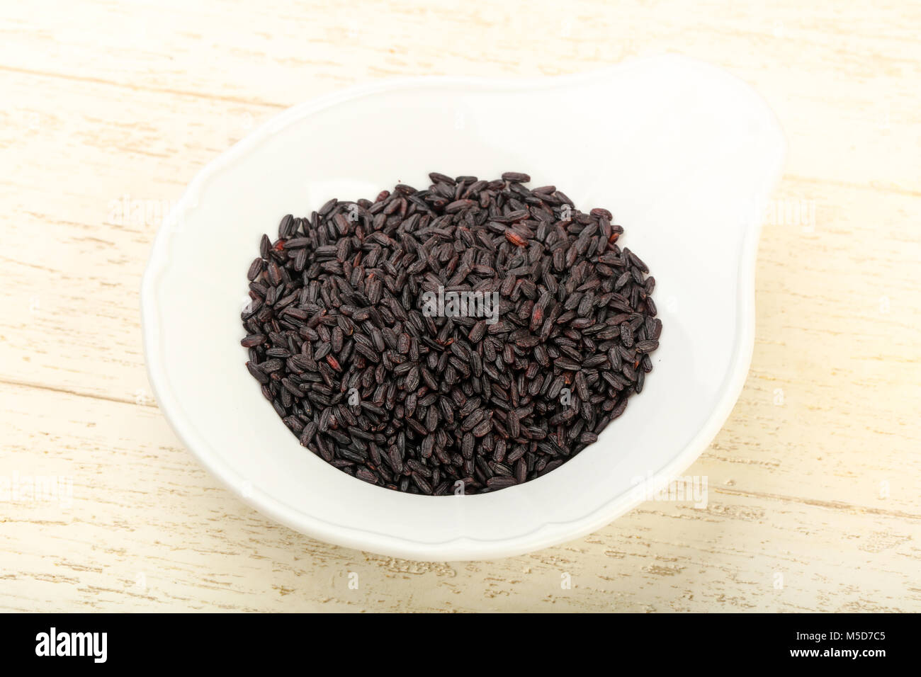 Black wild rice in the bowl over wooden background Stock Photo - Alamy